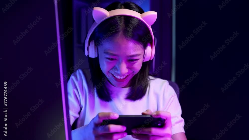 Video „A beautiful female gamer happily plays in a private room with ...