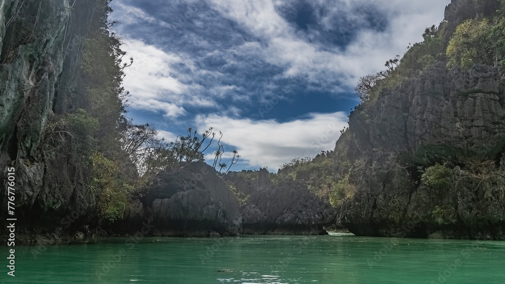 Picturesque karst limestone cliffs with steep slopes surround the bay ...
