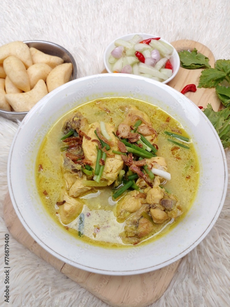 Gulai ayam or chicken curry served in a white bowl. A soupy dish made ...