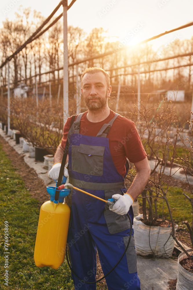 Farmer using pesticide, insecticide and herbicide sprayer sprinkler in ...