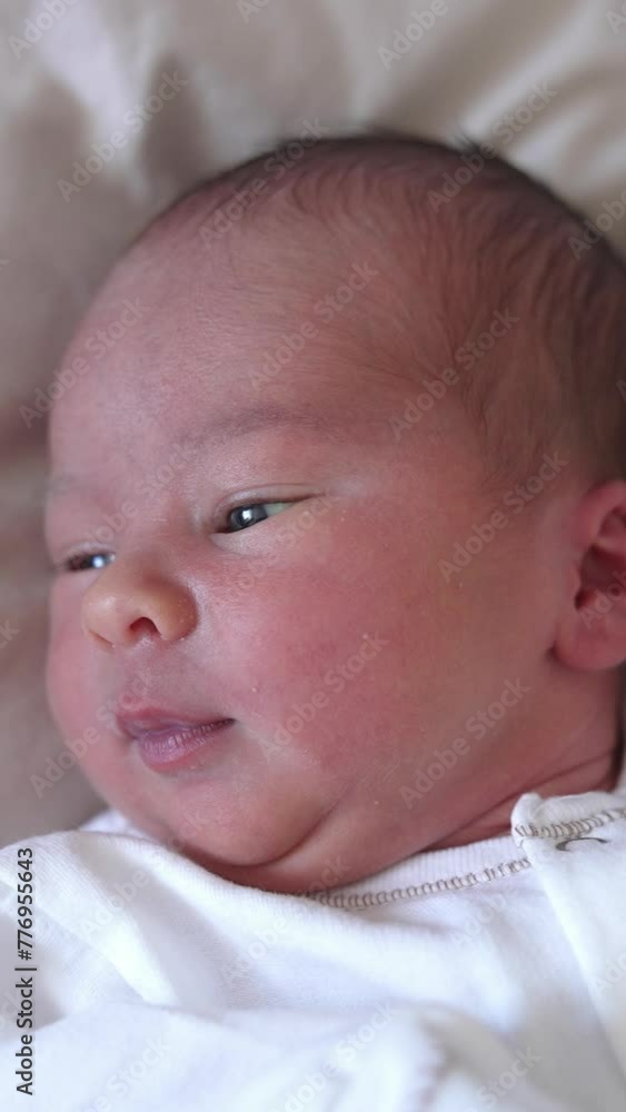 Sweet newborn boy is lying on the bed and turning his little head back ...