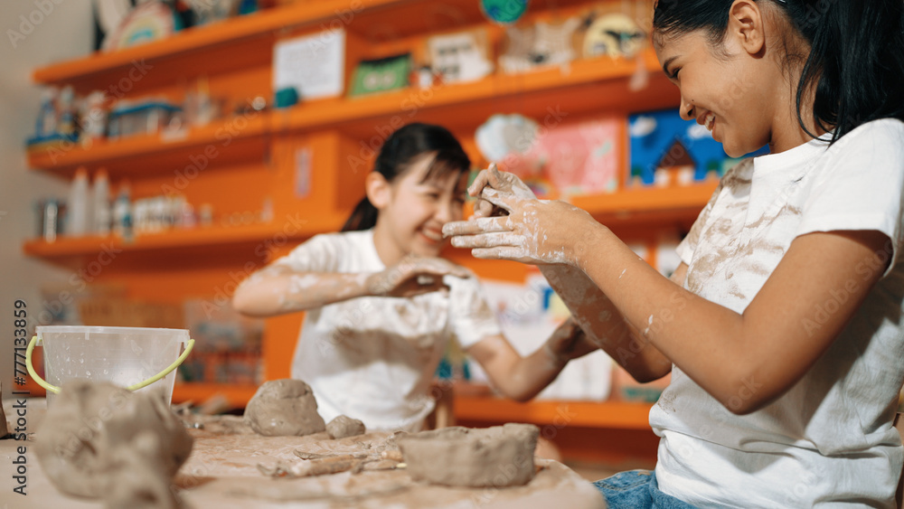 Happy multicultural girl and friend put the clay on the each other ...