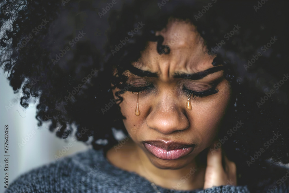 A close-up of a person's tear-streaked face, conveying profound sadness and grief, with watery ...