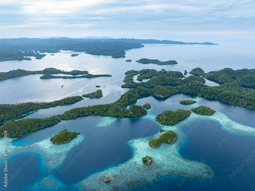 The scenic limestone islands of Pef, fringed by reef, rise from Raja ...