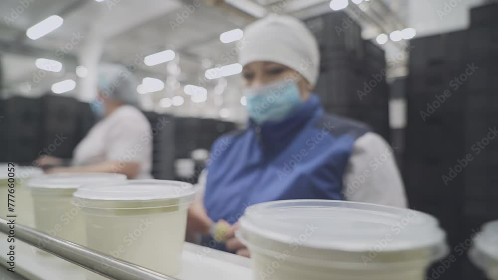 Two Female Operators Sticking Labels on the Side and Top of Containers ...