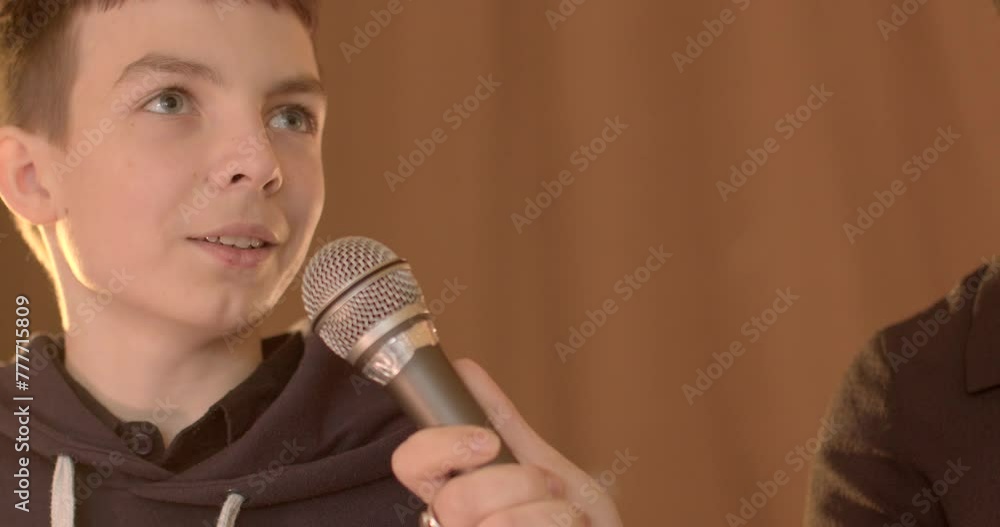 Close-up teenage student speaks into microphone during school debate ...