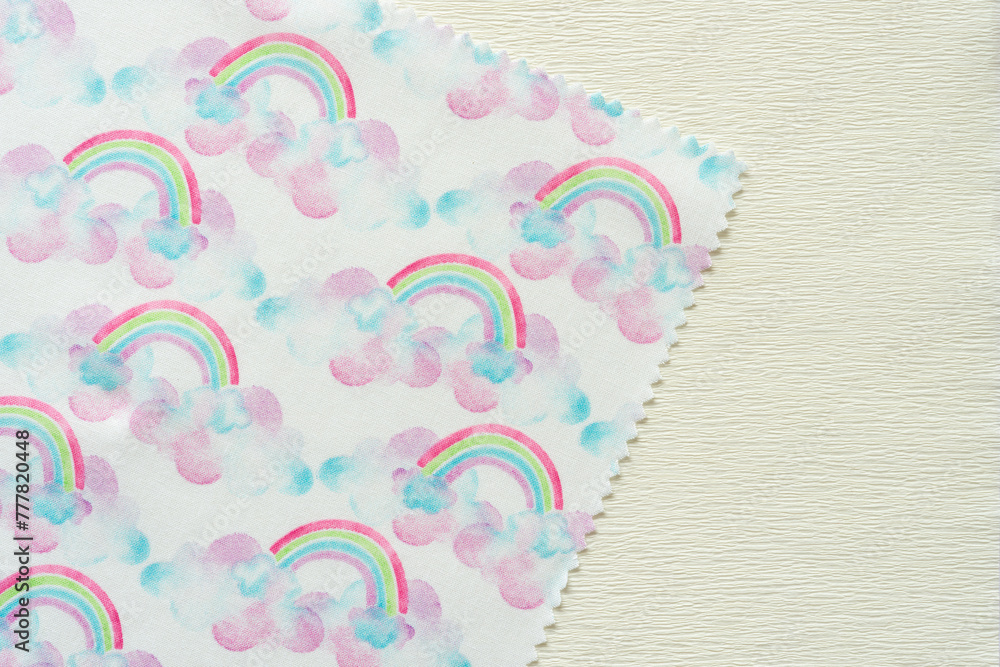 corner of fabric doily with rainbows and clouds print pattern on crepe ...