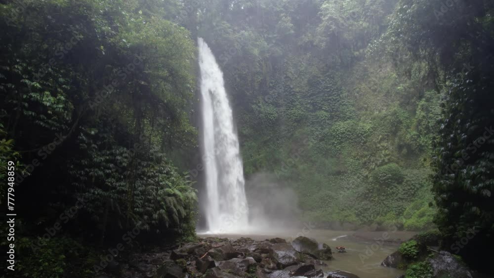 Rushing stream of water in large waterfall, around on the vertical ...