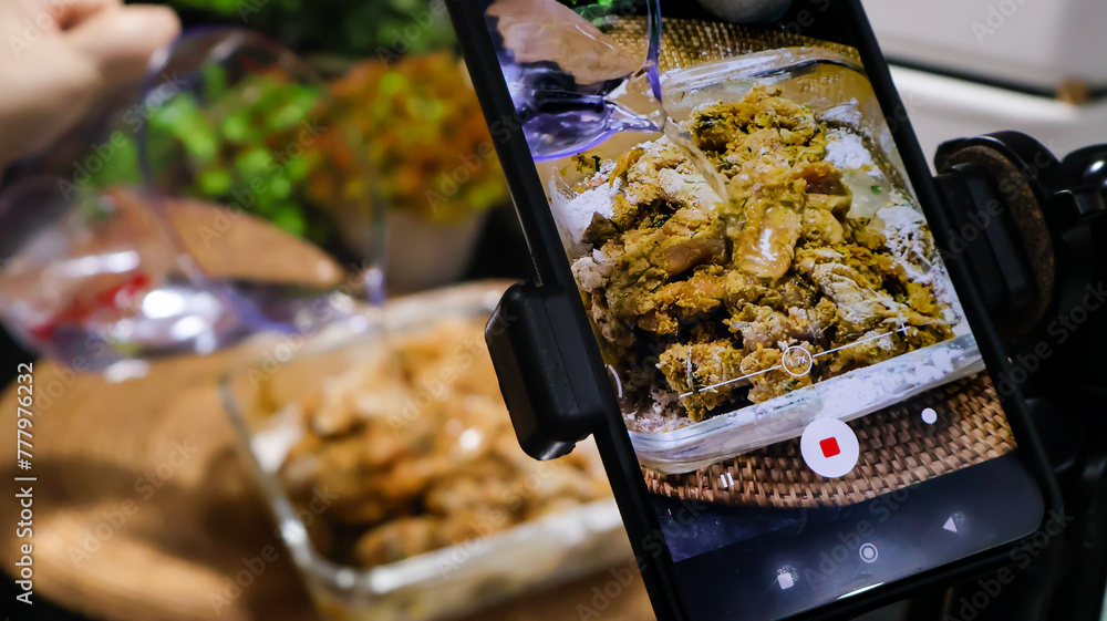 Close up of a female food vlogger filming herself cooking in the ...