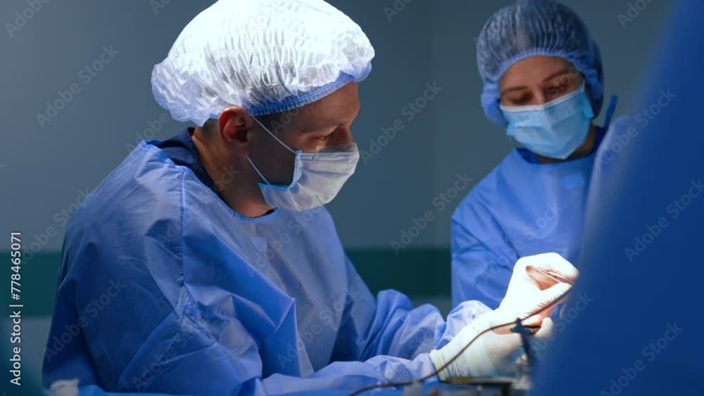 Confident calm male surgeon uses metal tools at neurosurgical operation ...