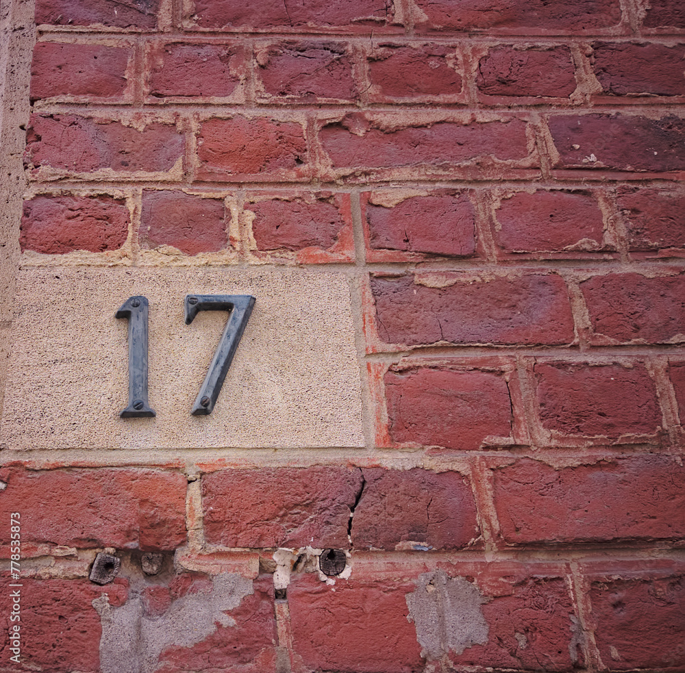Number with the number seventeen or 17 in Latin. An old red brick wall ...