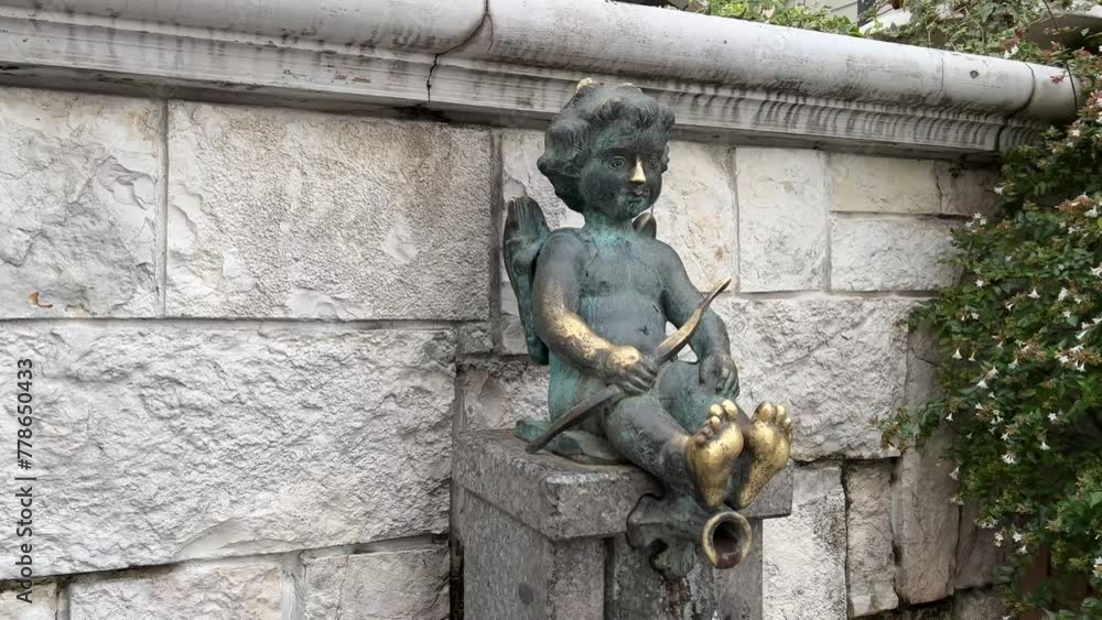 Horizontal 4K video. Sculpture of cupid at fountain. Bronze statue of ...