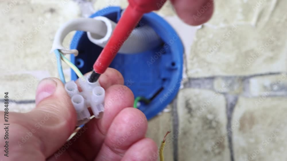 Electrician connects wires with screw clamp fixing terminal block in ...