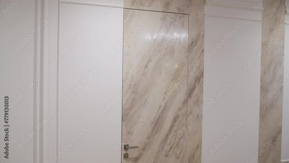 Marble door in a luxurious interior with elegant white molding and a ...