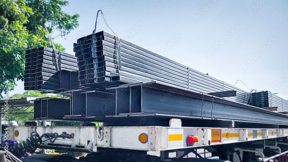 Trucks with long trailers carrying steel bars for building construction ...