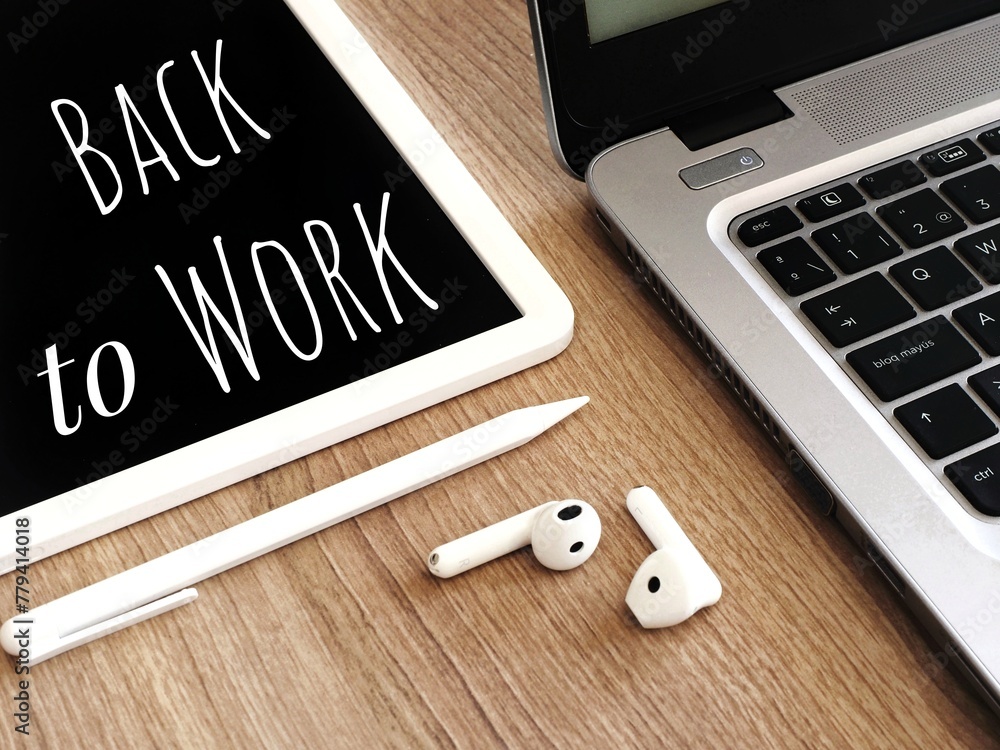 Back to work background with text, laptop and earbuds. Welcome back to ...