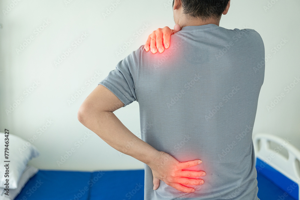 Young man with back pain touching his lower back and neck Waking up ...