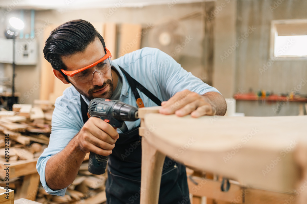 Diligently skilled man work with wood in carpenter's shop, using tools ...
