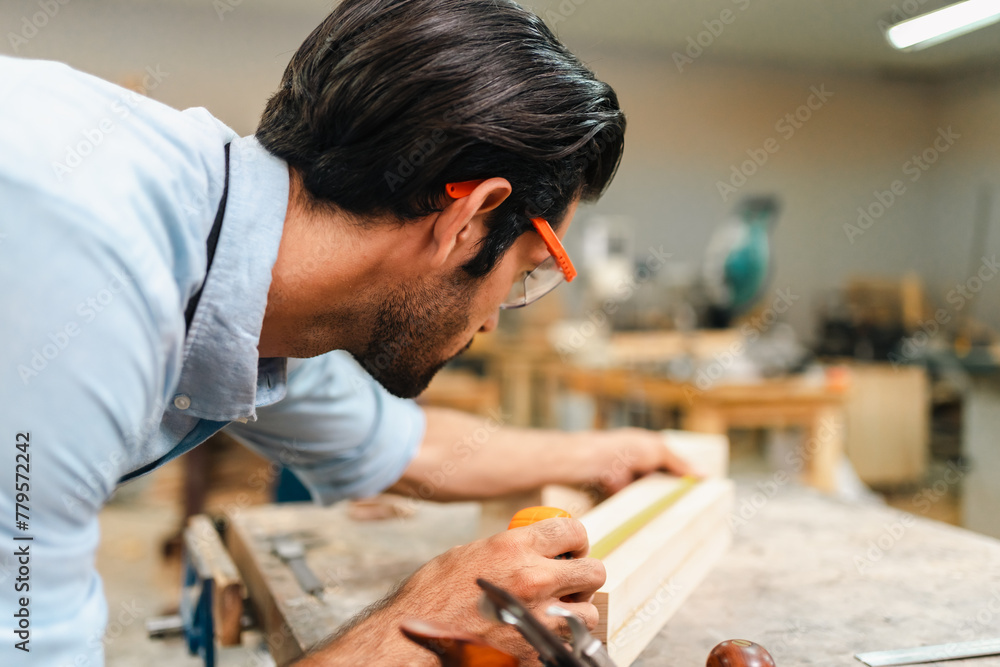 Diligently skilled man work with wood in carpenter's shop, using tools ...