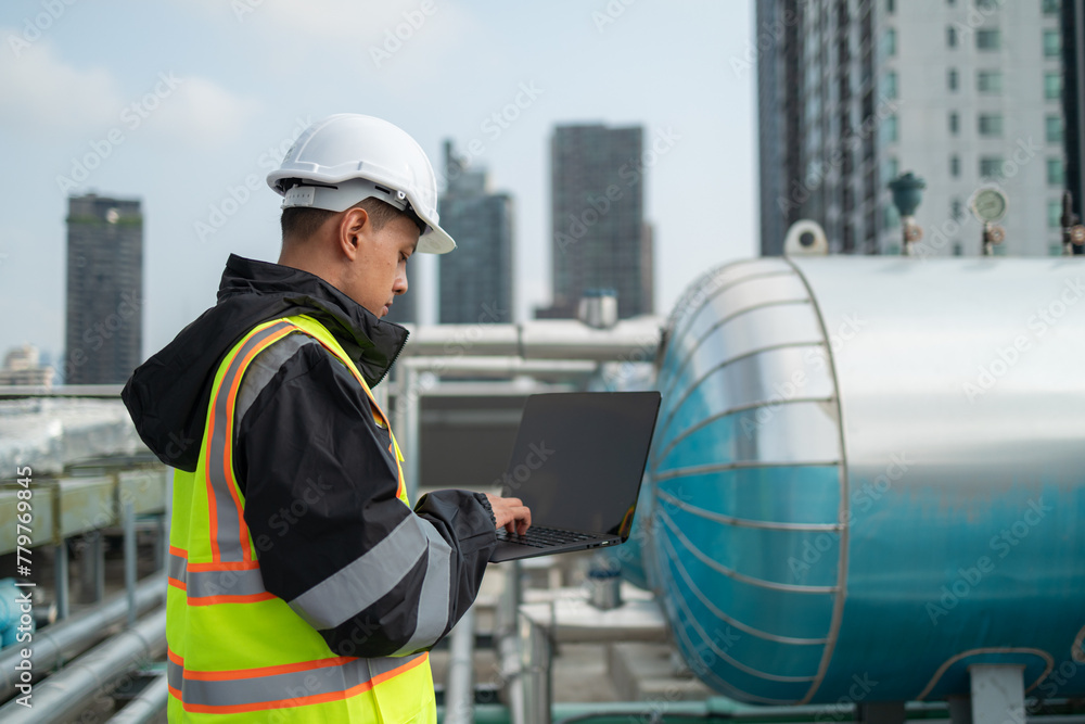 Engineer inspects water heater pump system and hot water tank on ...