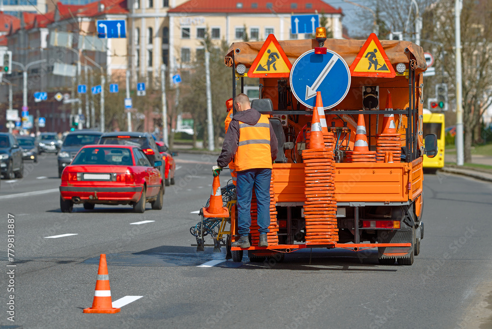 Road marking works. Workers uses paintliner truck to apply fresh paint ...