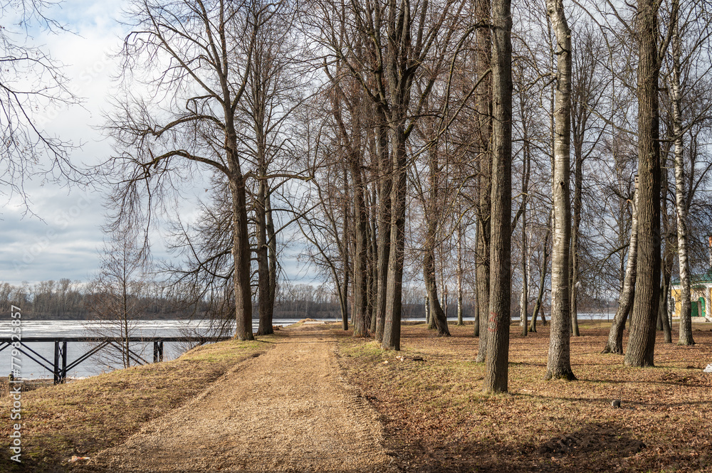City park with alleys, walking paths and benches, a flowing river ...