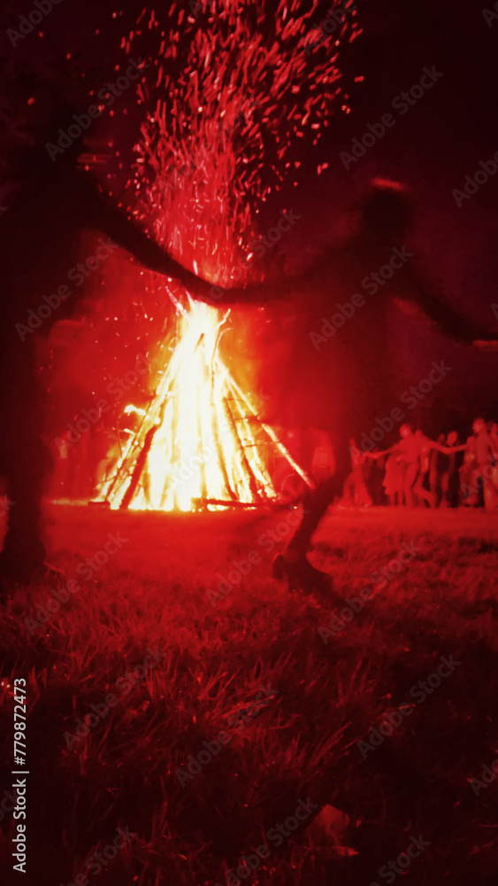 Huge fire at night and young people around. Pagan festival of Walpurgis ...