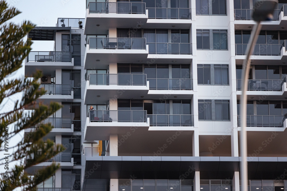 Pre-teen boy standing on balcony of high rise apartment building on the ...