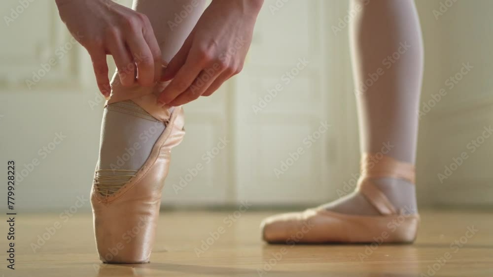 Ballerina puts on pointe shoes on leg in dance class. Classical ballet ...