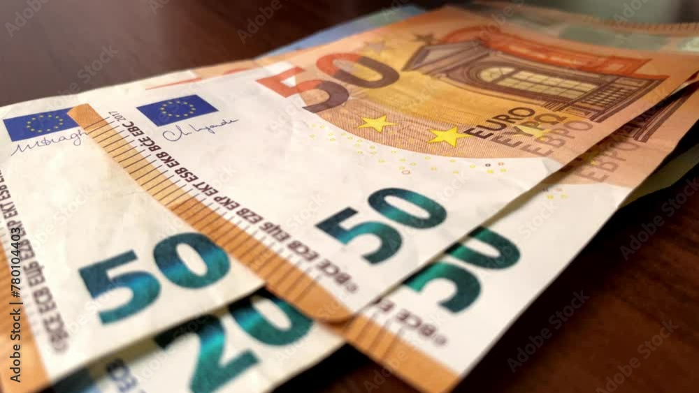 Closeup of Euro banknotes being counted and falling gracefully onto ...