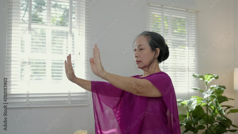 an old woman is doing yoga in the living room in the morning which is ...