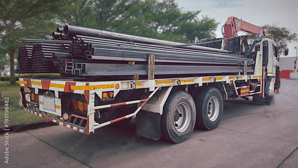 Trucks with long trailers carrying steel bars for building construction ...