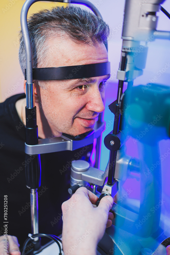 Checking a man's vision with a modern microscope at an appointment with ...