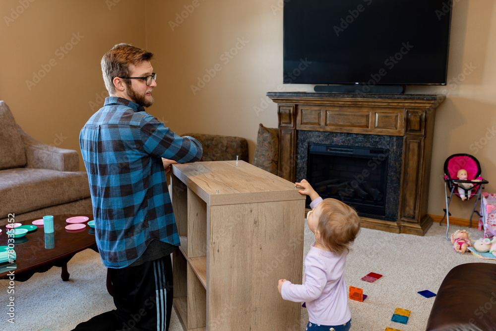 Dad building shelves with his one year old daughter at home Stock Photo ...