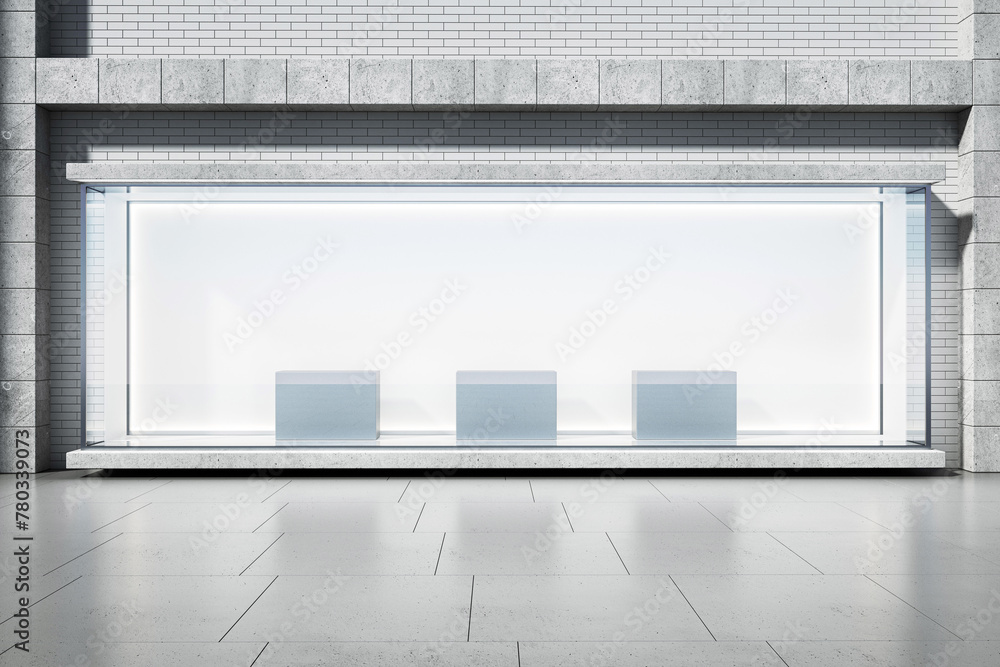 An empty storefront with large window display and three mockup podiums ...