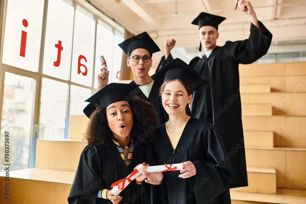 Multicultural students in graduation gowns and caps happily posing for ...