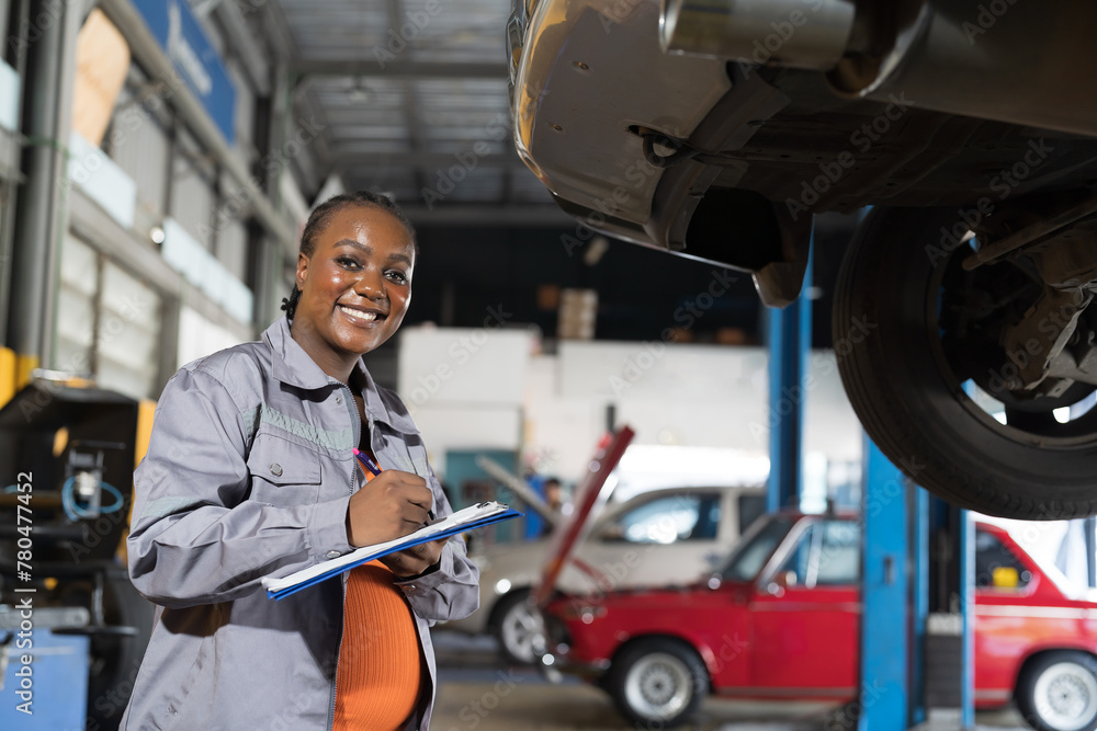 Female mechanic working at garage. Female mechanics checking car engine ...