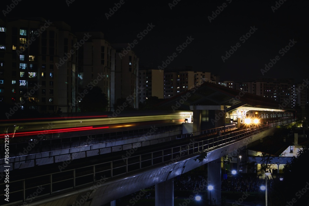 Singapore MRT track and station at night with light trail from train ...