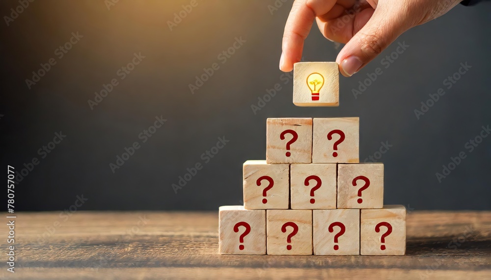 Hand put the last wooden cubes on the top of a pyramid built by wood ...