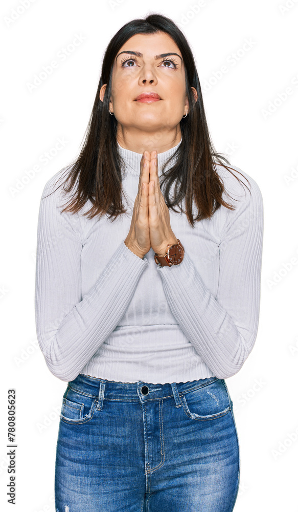 Beautiful brunette woman wearing casual clothes begging and praying ...