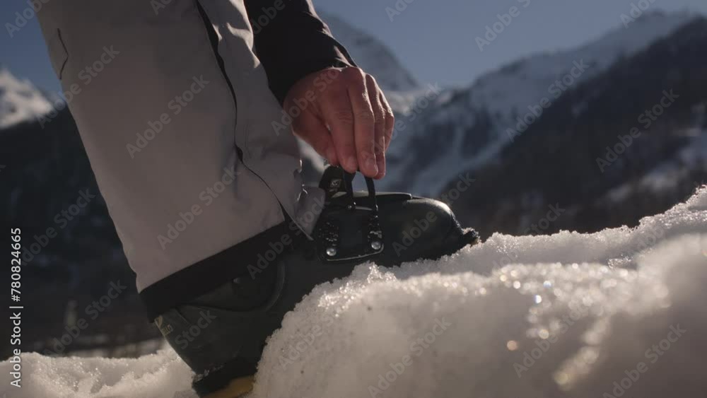 Skier puts his foot on the snow, fastens the clasp. Adjusting boat ...