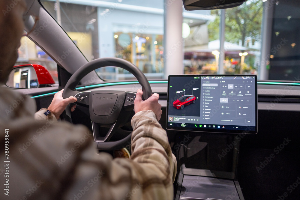 Tesla test drive, Young man, potential buyer, sits in car interior ...