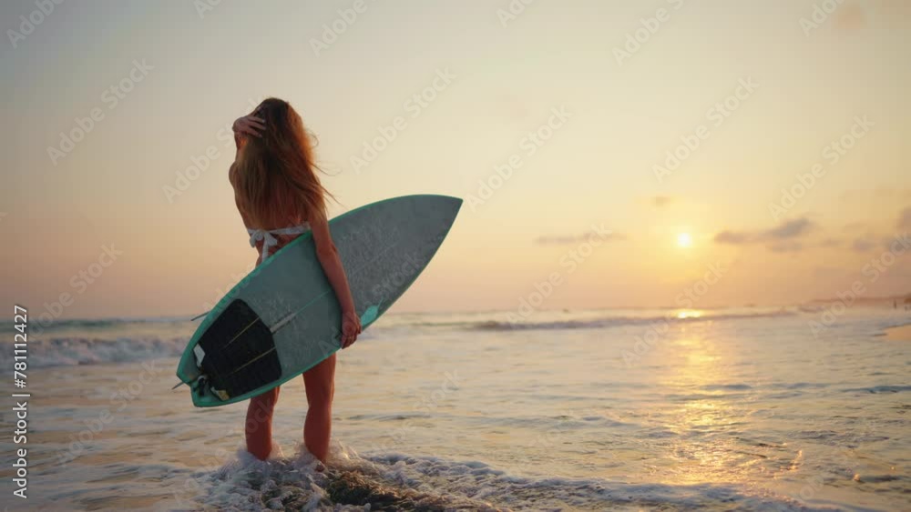 Blonde woman surfer in swimsuit holds surfboard in hands stands on ...