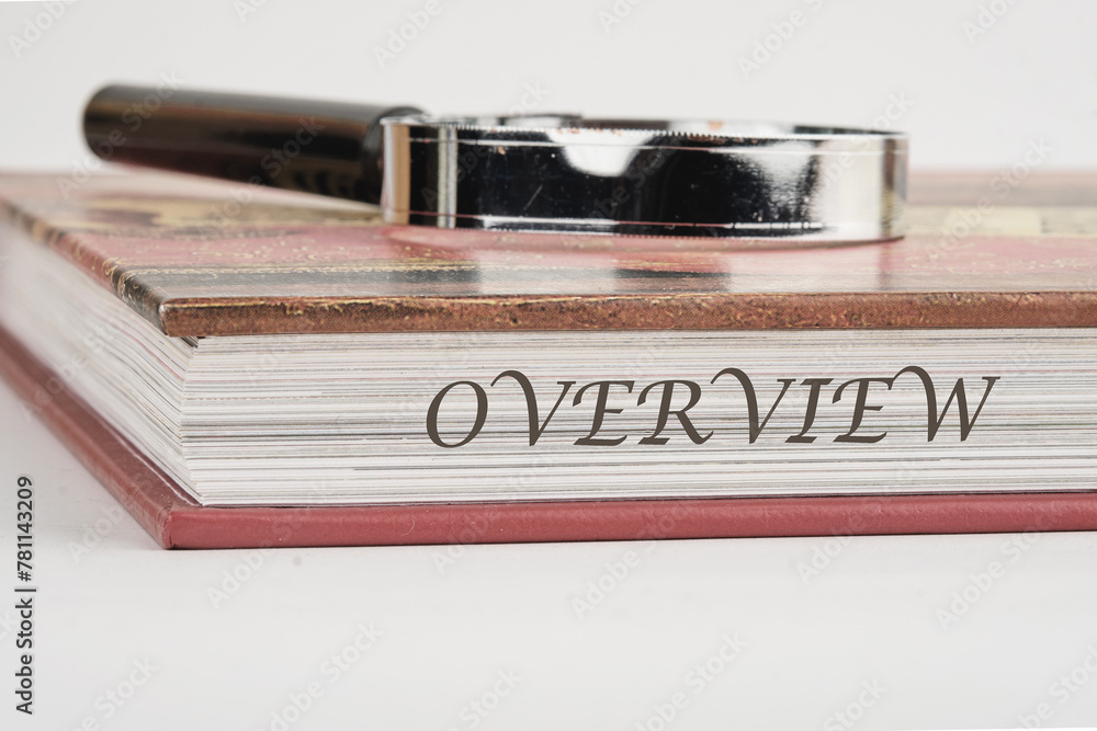OVERVIEW written on a book with a magnifying glass on top on a white ...