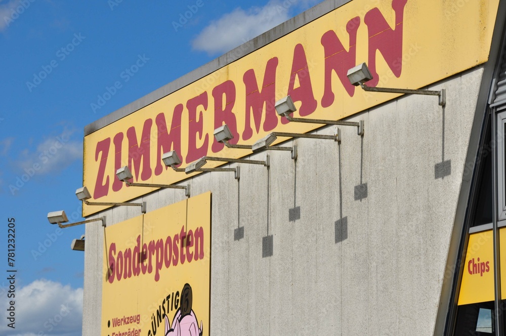 Zimmermann Sonderposten: Rotgelbes Schild mit Logo und Firmenname außen ...