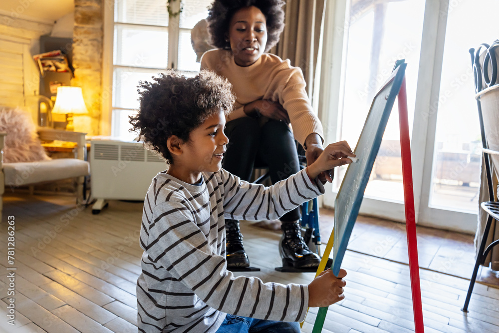 Happy child doing math exercises with her mother or teacher together ...
