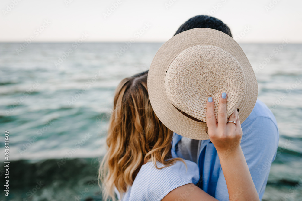 Hat hidden face. Female and male hide faces behind straw hat and kiss ...