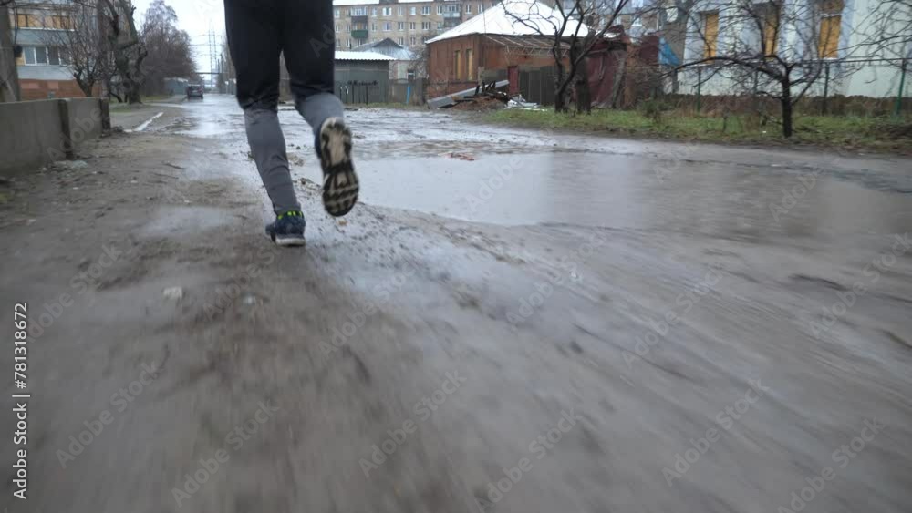 Male feet of sporty runner jogging along country road. Legs of young ...