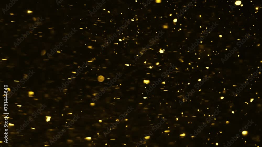 Golden glitter background in slow motion. Beautiful transition with real gold particles flying ...