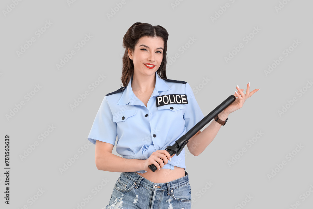Beautiful pin-up police officer with baton on grey background Stock ...